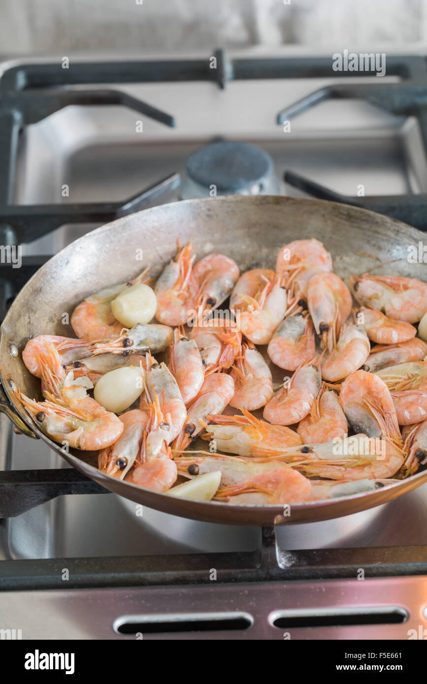 Prawns in a copper pan on a gas stove Stock Photo - Alamy
