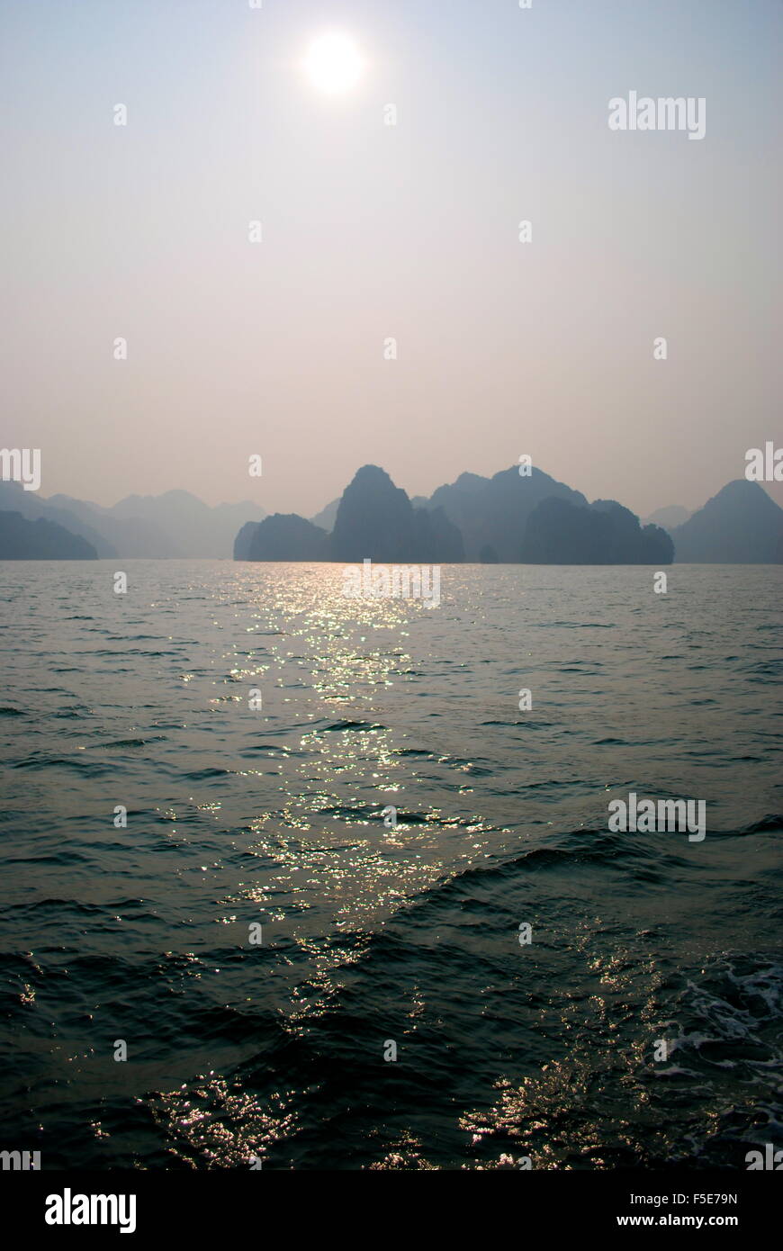 Sun over rock islands in Halong Bay, Vietnam, Southeast Asia Stock ...