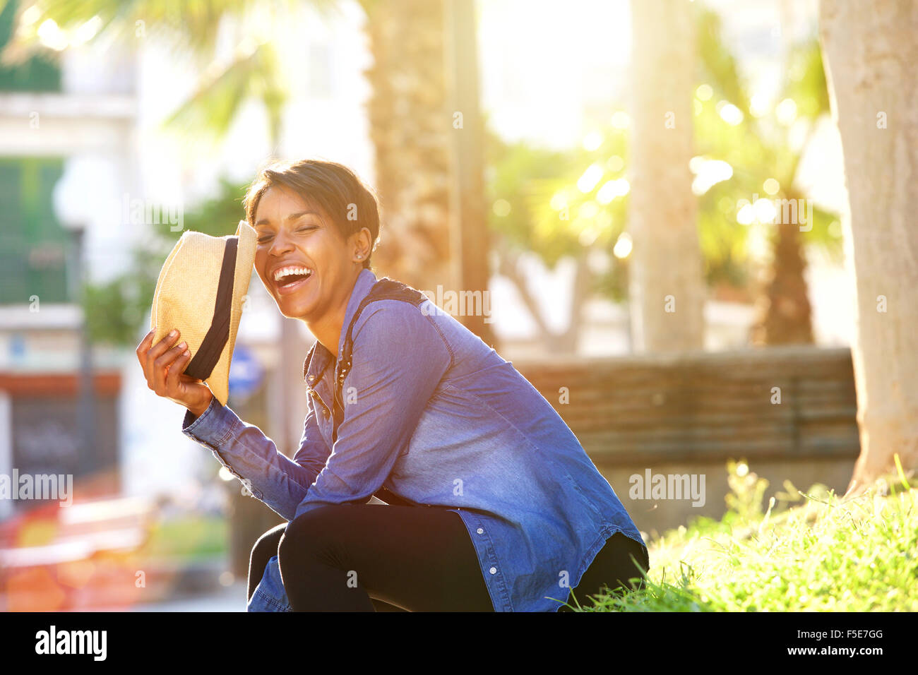 Side portrait of a carefree young woman laughing outside Stock Photo ...
