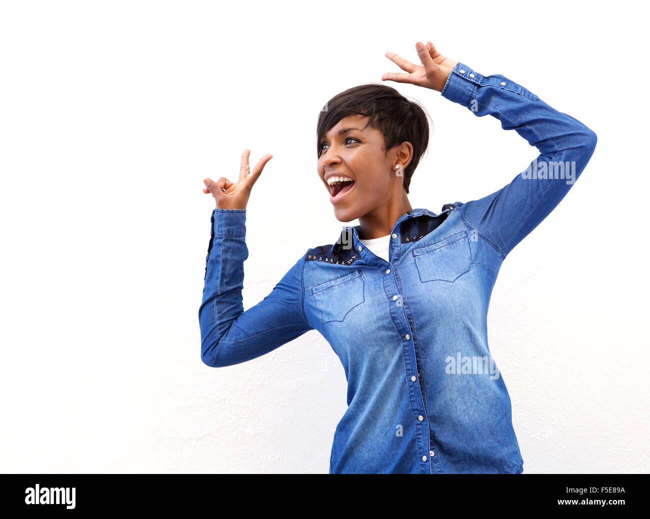 Portrait of a smiling african american woman standing with peace sign ...