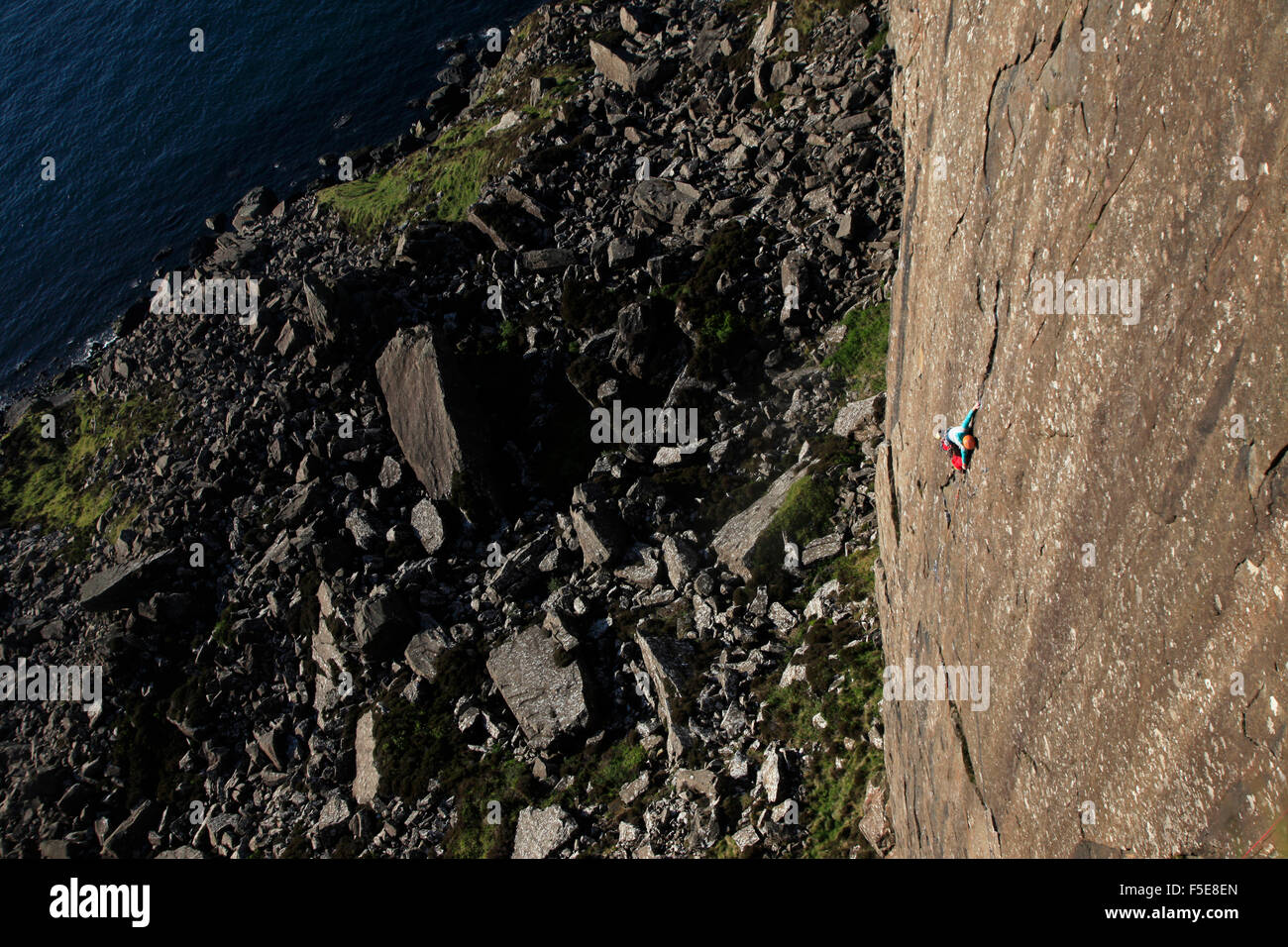 A climber scales the 100 metre cliffs at Fair Head, County Antrim ...