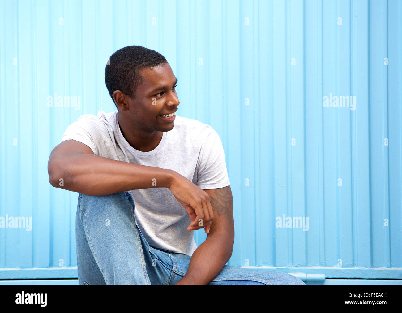 Man sit against wall hi-res stock photography and images - Alamy