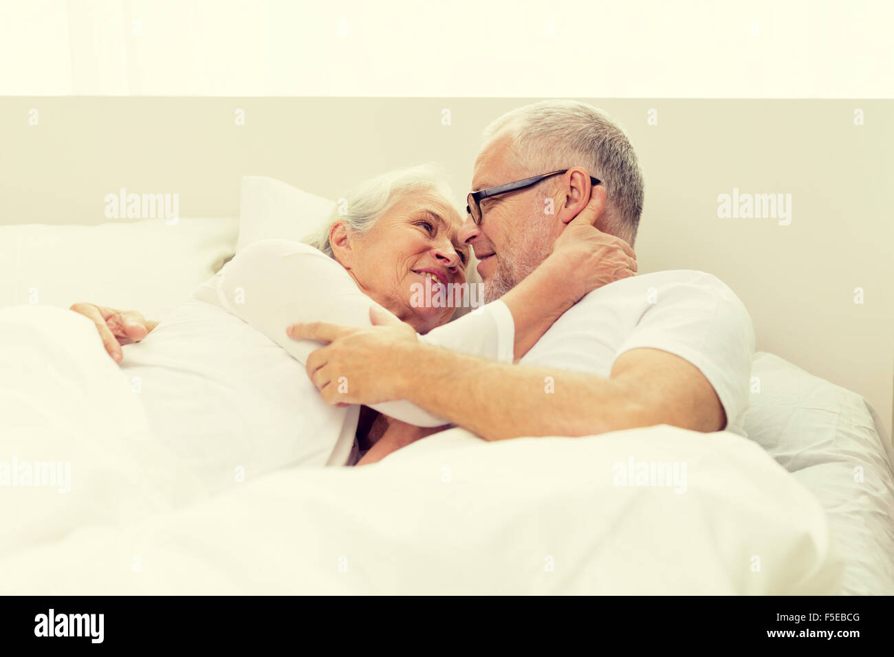 Relaxed couple kissing in bed hi-res stock photography and images - Alamy