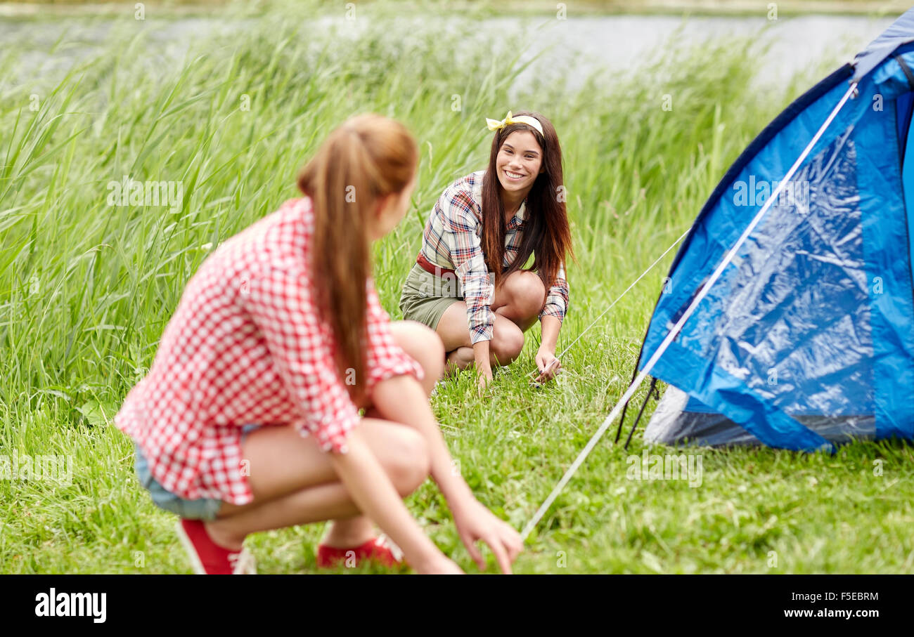 smiling friends setting up tent outdoors Stock Photo - Alamy
