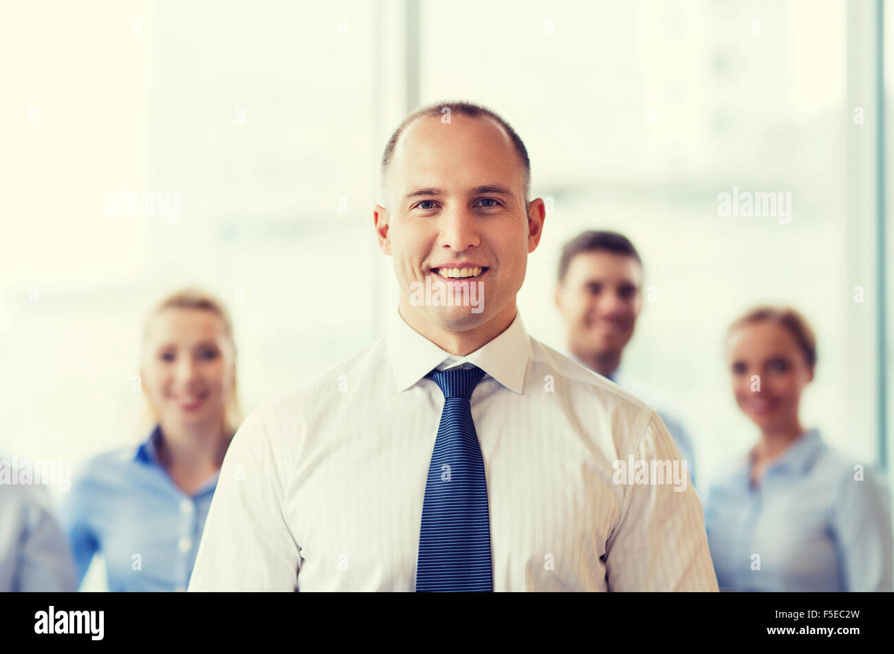 smiling businessman with colleagues in office Stock Photo - Alamy