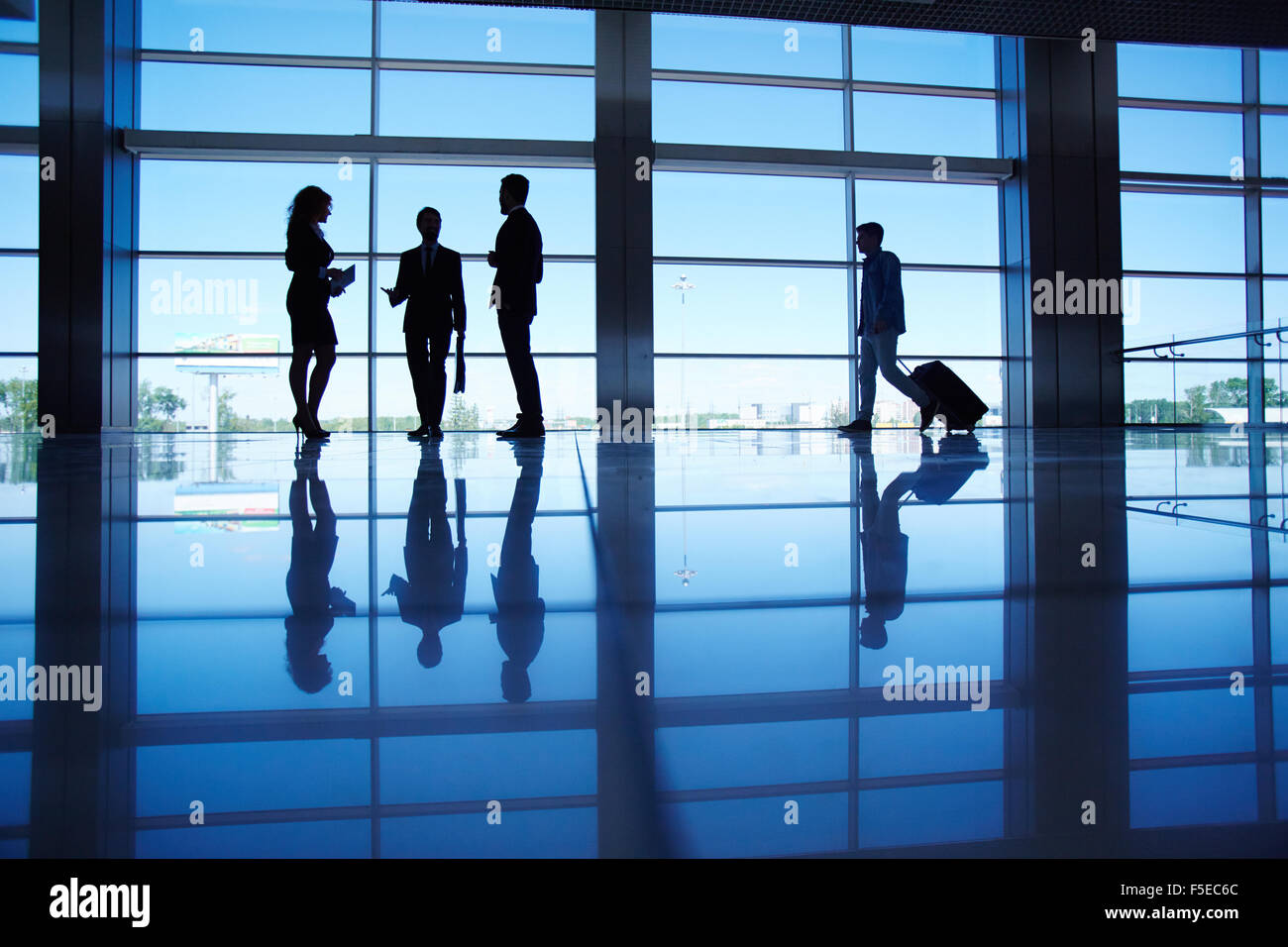 Several office workers talking by the window inside modern office ...