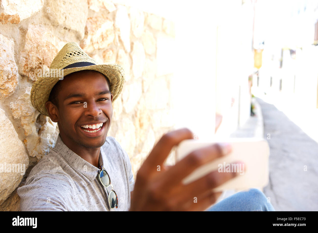 Cheerful young man taking selfie on vacation Stock Photo - Alamy