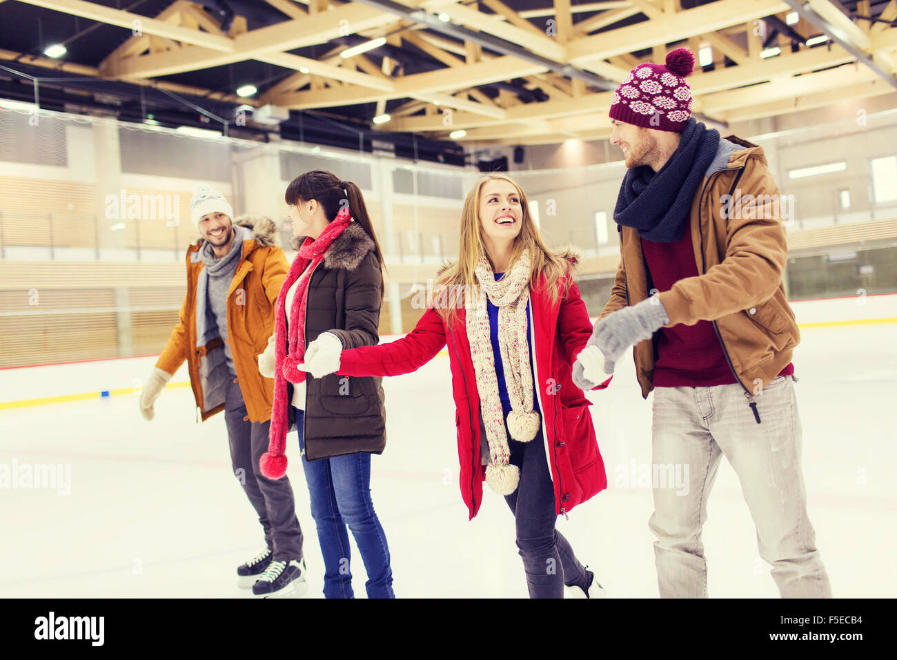 happy friends on skating rink Stock Photo - Alamy