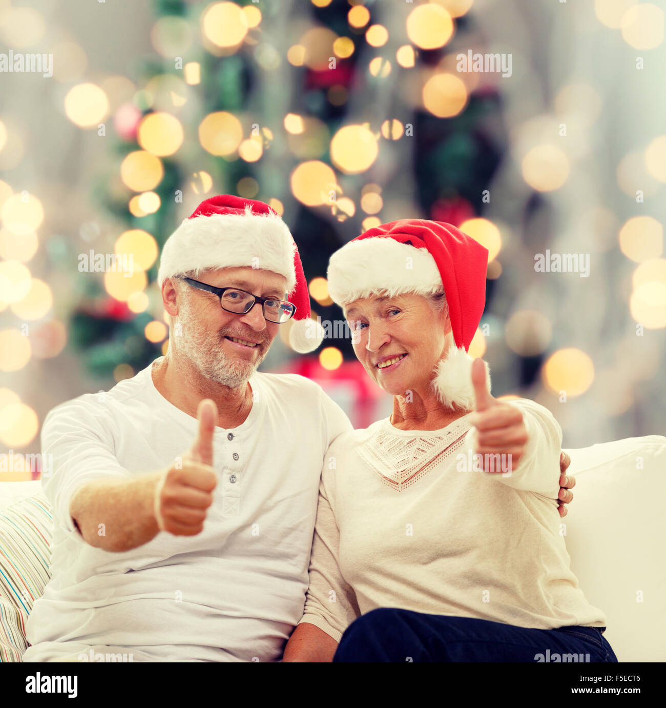 happy senior couple in santa helper hats Stock Photo - Alamy