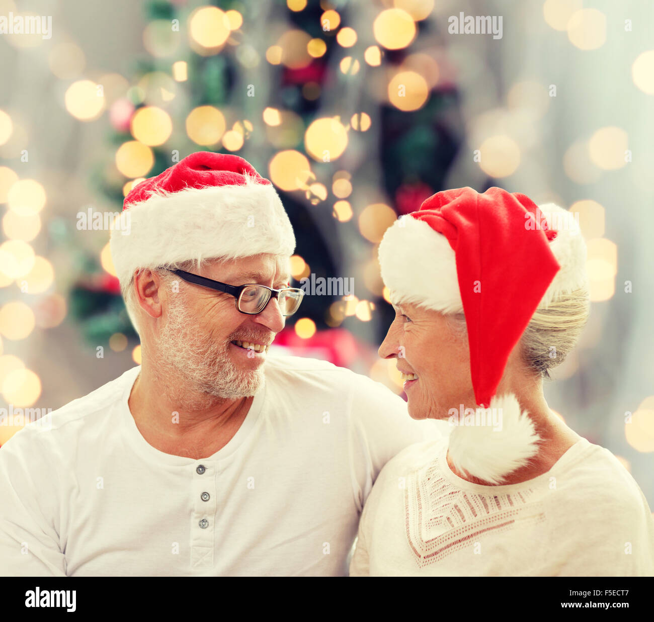 happy senior couple in santa helper hats Stock Photo - Alamy