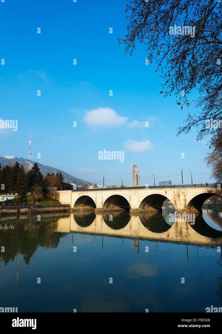 Arched bridge reflecting in Mtkvari River, Tbilisi, Georgia, Caucasus ...