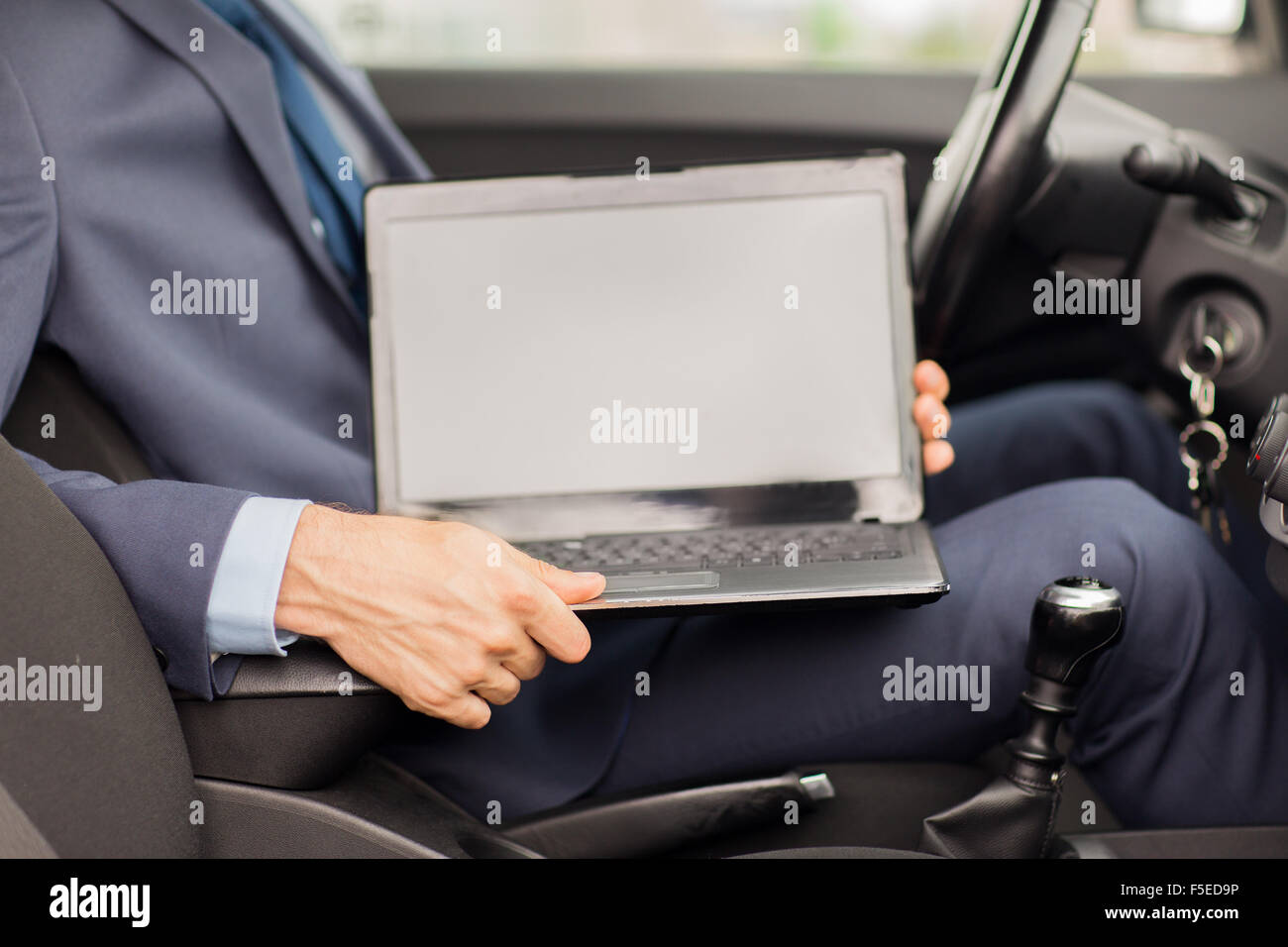 close up of young man with laptop driving car Stock Photo - Alamy