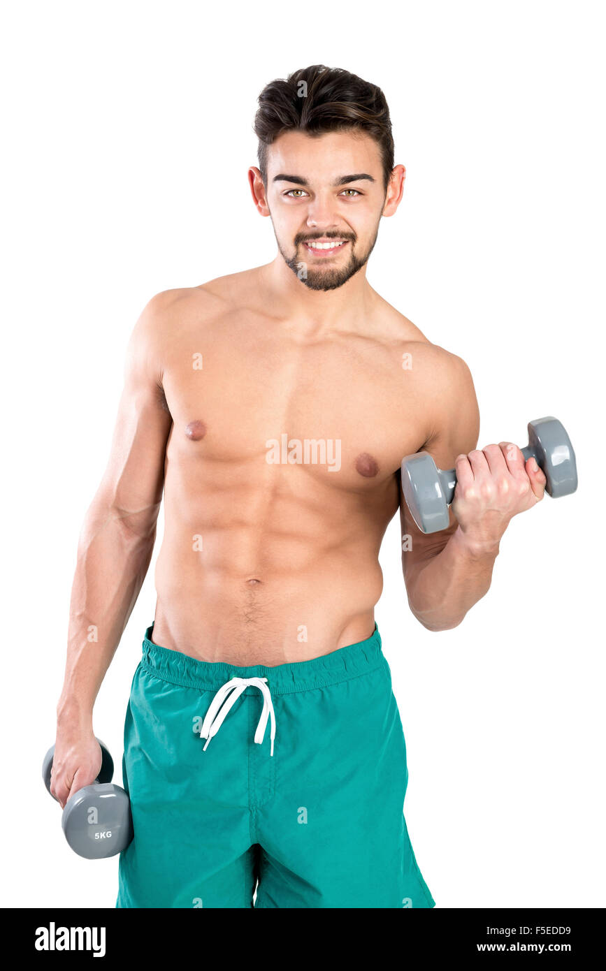 Handsome and fit young man exercising with dumbbells isolated in white ...