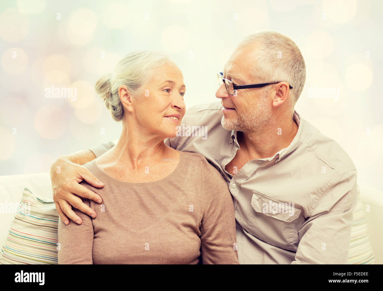 happy senior couple hugging on sofa at home Stock Photo - Alamy