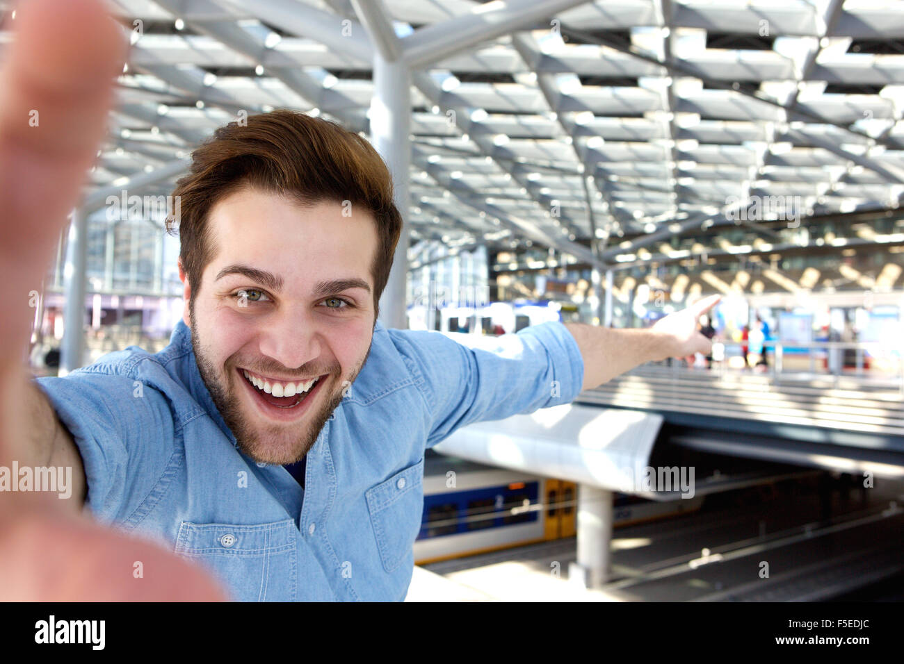 Portrait of a happy man taking selfie and pointing Stock Photo - Alamy