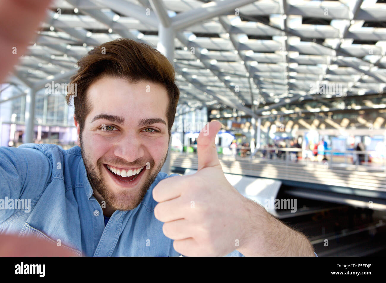 Portrait of a happy man taking selfie with thumbs up Stock Photo - Alamy