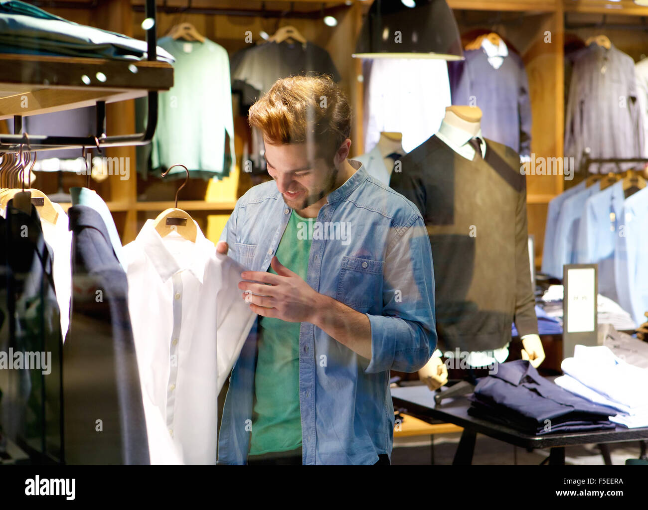 Portrait of a happy man shopping for clothes at clothing store Stock ...