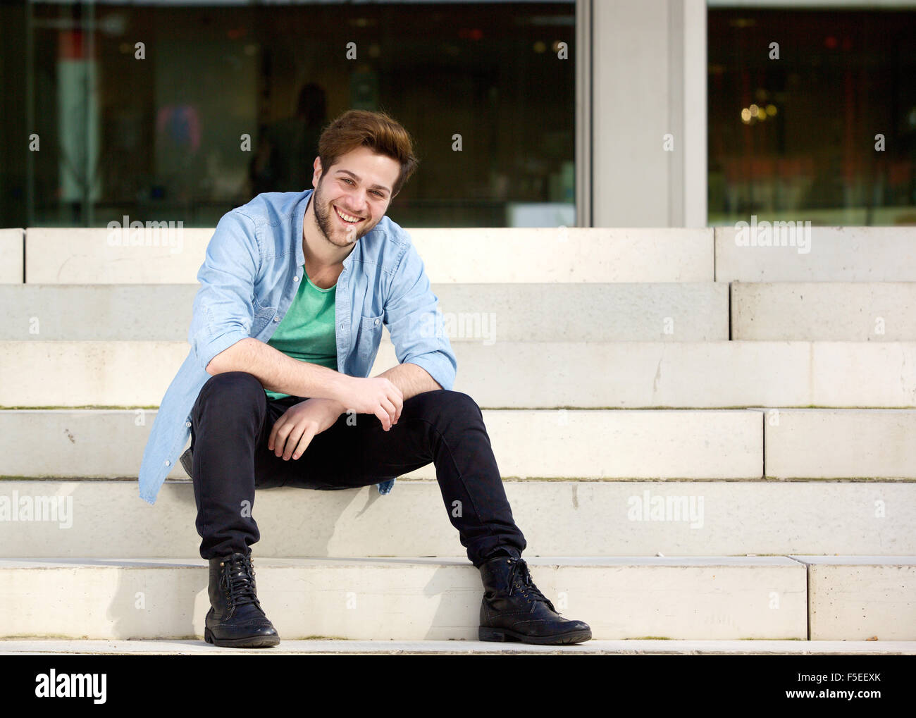 Portrait of a happy man sitting on steps outdoors Stock Photo - Alamy