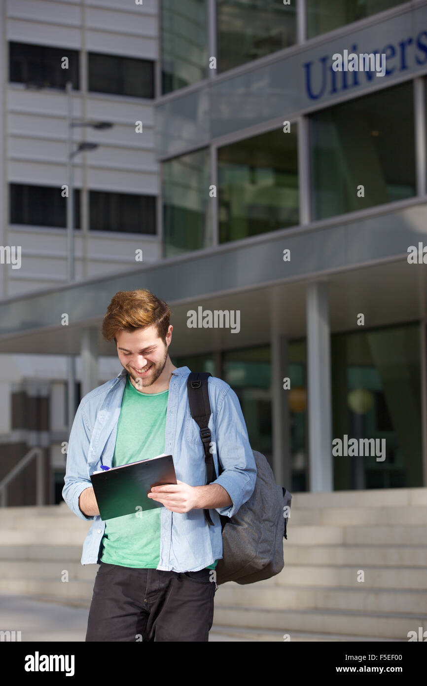 Portrait of a male student on campus writing on notepad Stock Photo - Alamy
