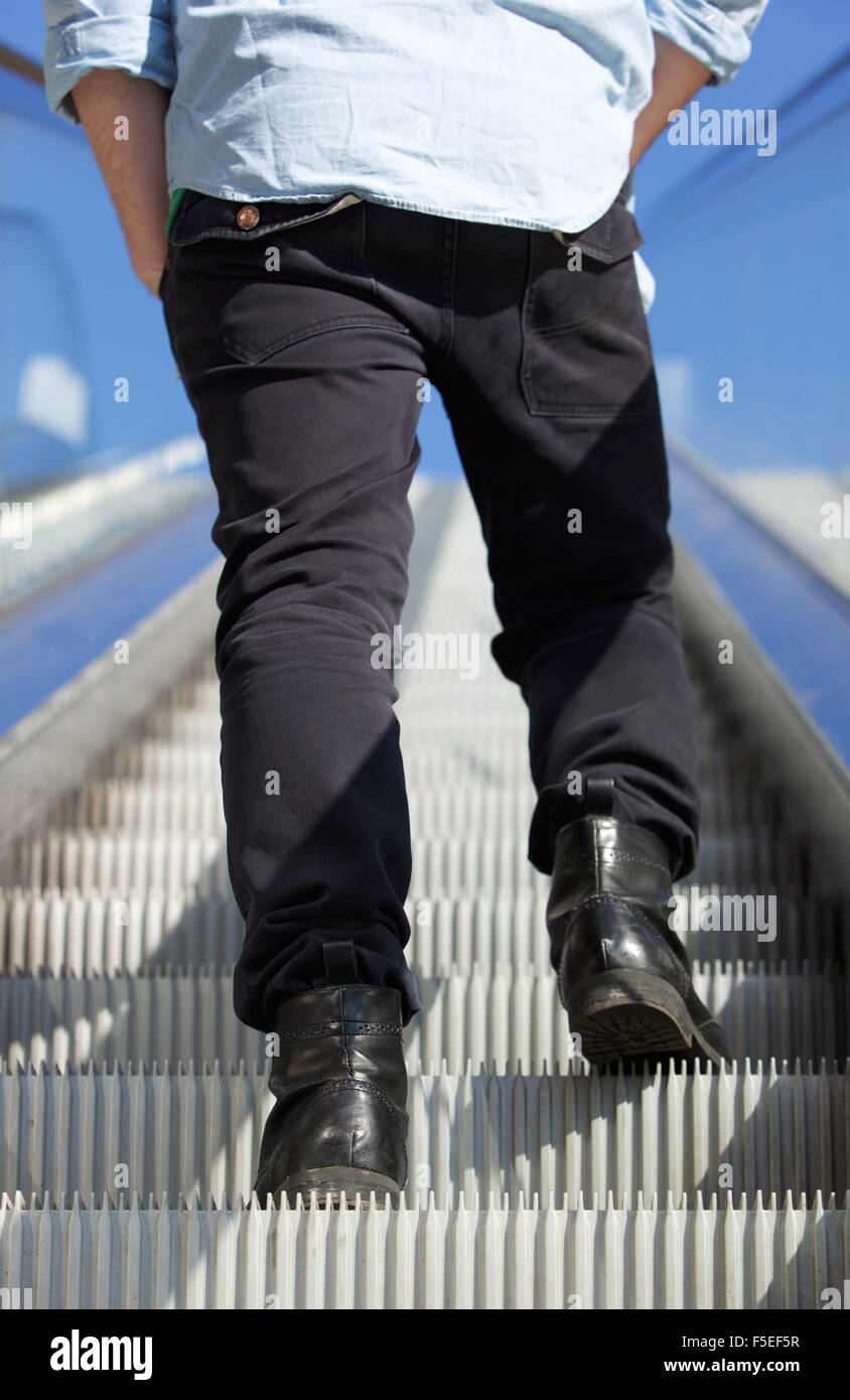 Rear view low angle man standing on escalator Stock Photo - Alamy