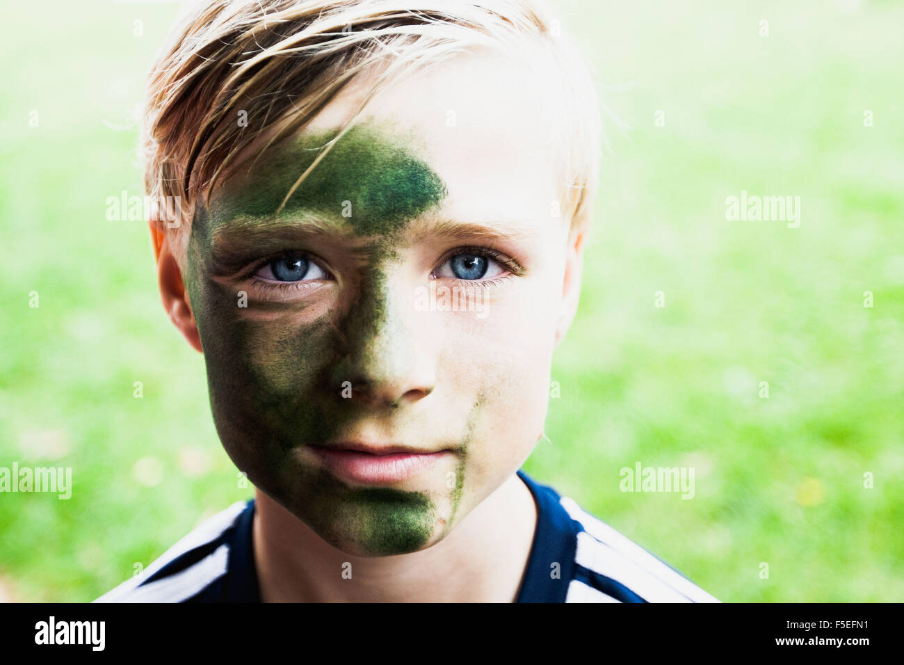 Portrait of a young boy getitng his face painted Stock Photo - Alamy