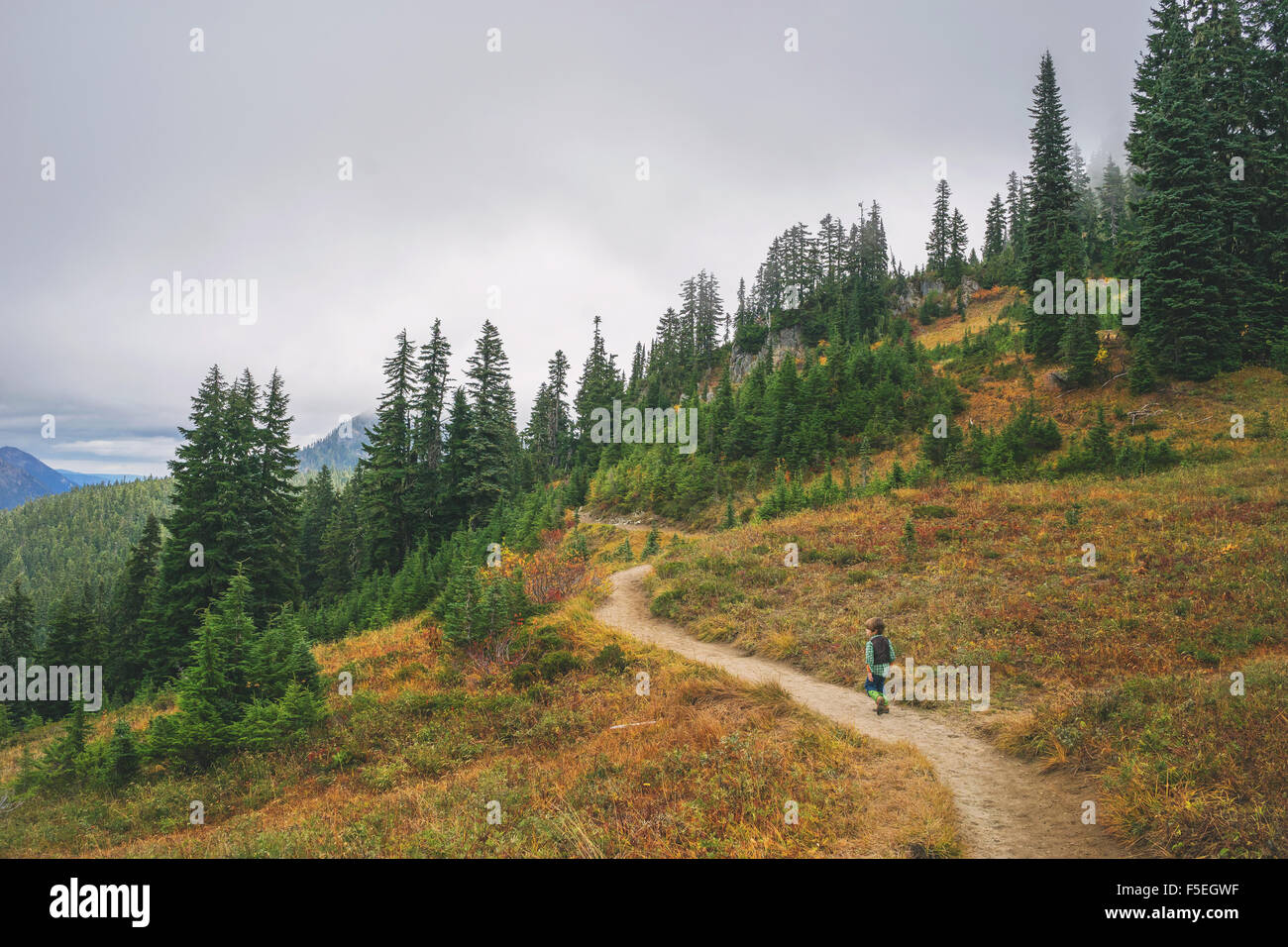 Boy walking along mountain path Stock Photo - Alamy
