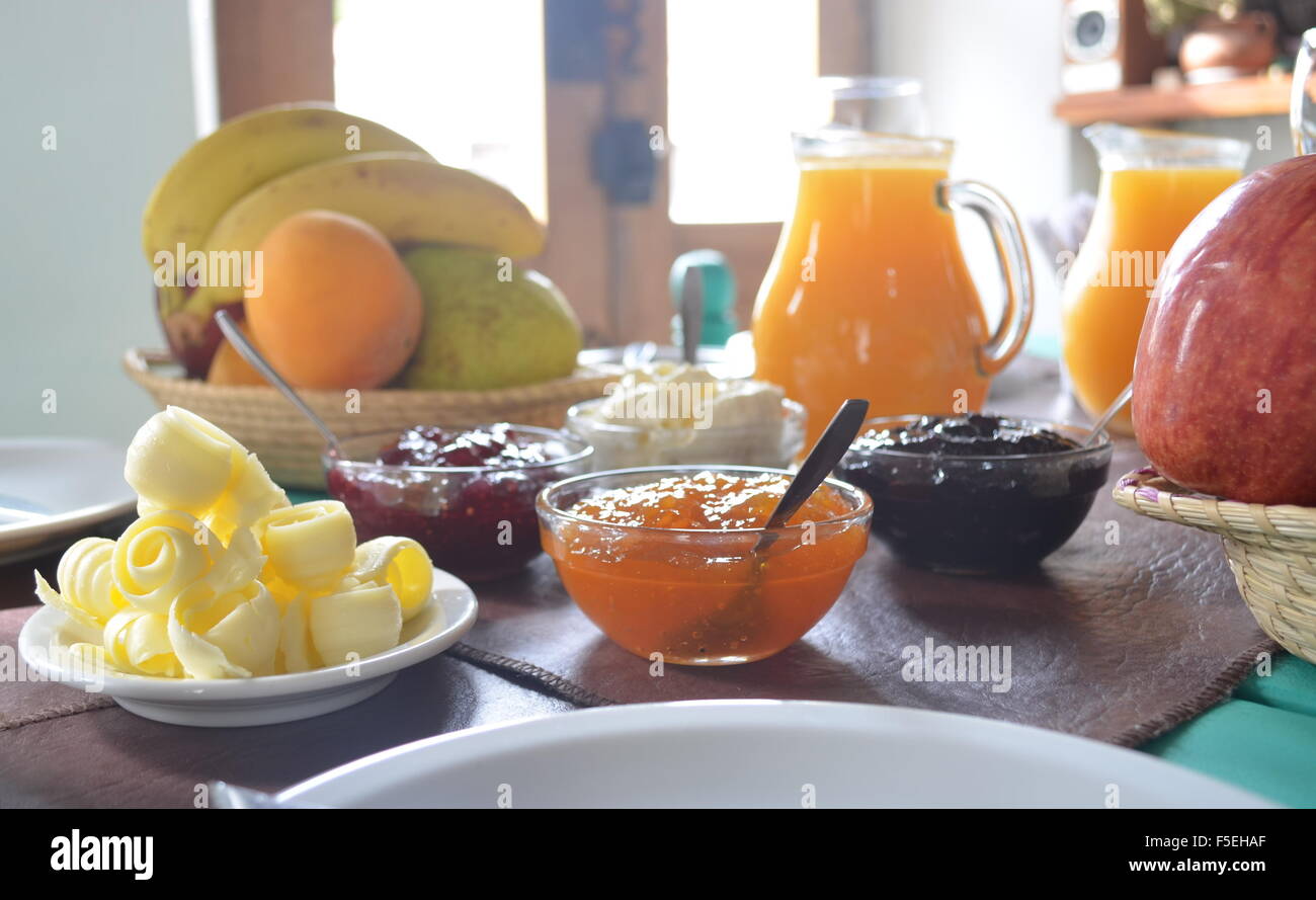 Jams, fruit, juice and butter on breakfast table Stock Photo - Alamy
