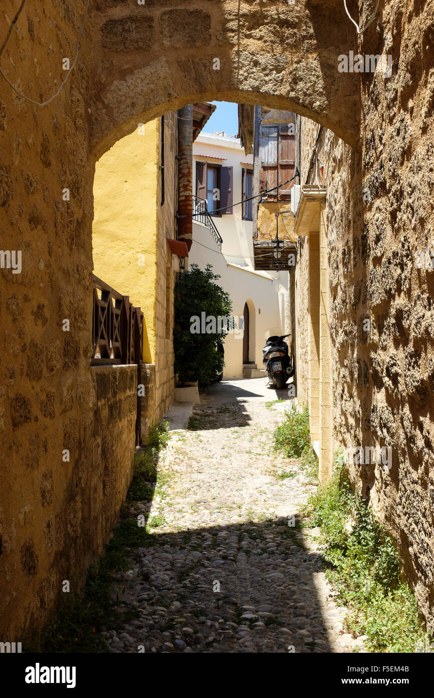 Narrow backstreet with overhead arches in the old town of Rhodes ...