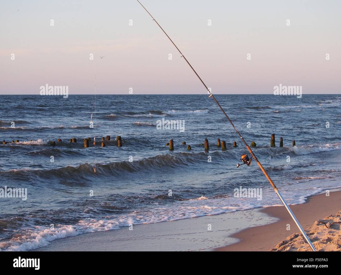 fishing-rod with spinning-wheel on sea background Stock Photo - Alamy