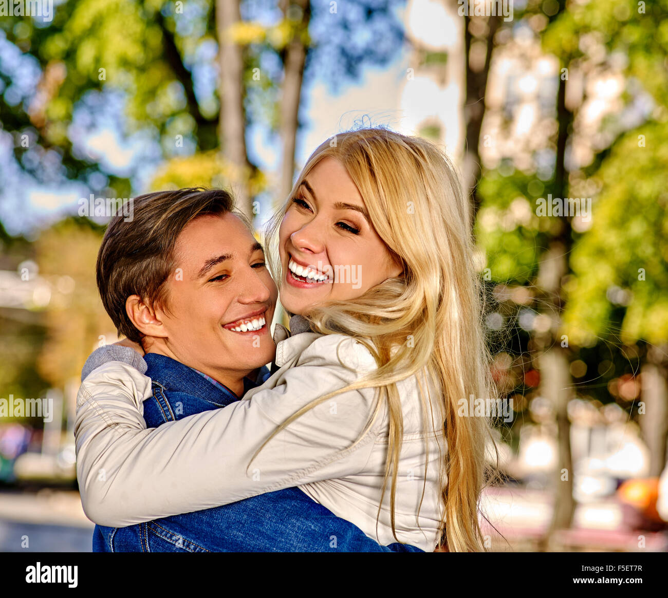 Young couple gently hugging and flirting in park Stock Photo - Alamy