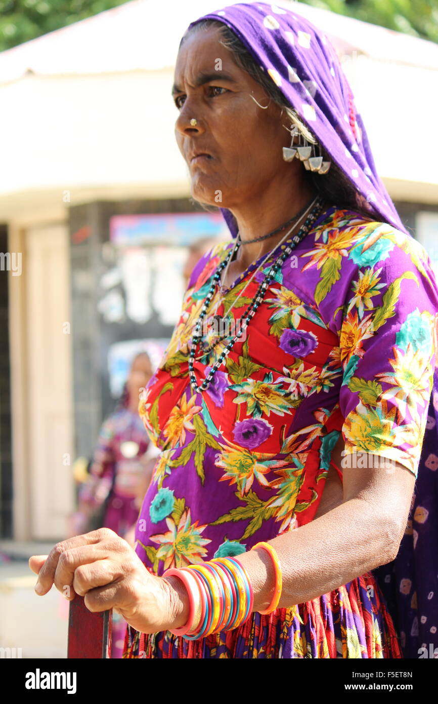 Aged lady with colorful clothes holding a pole Stock Photo - Alamy