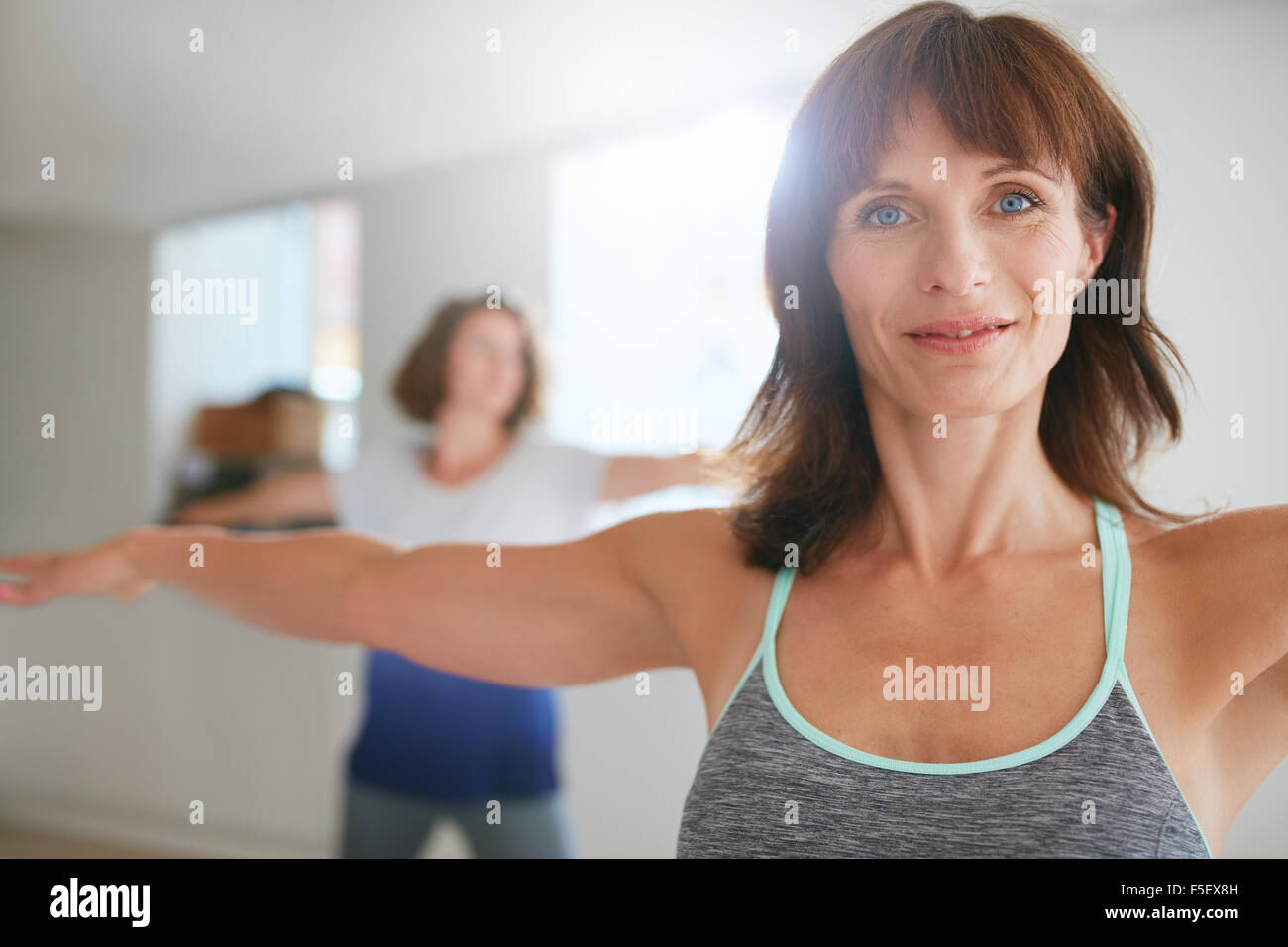 Two Women Doing Stretching And Yoga Workout At Gym Female Trainer With