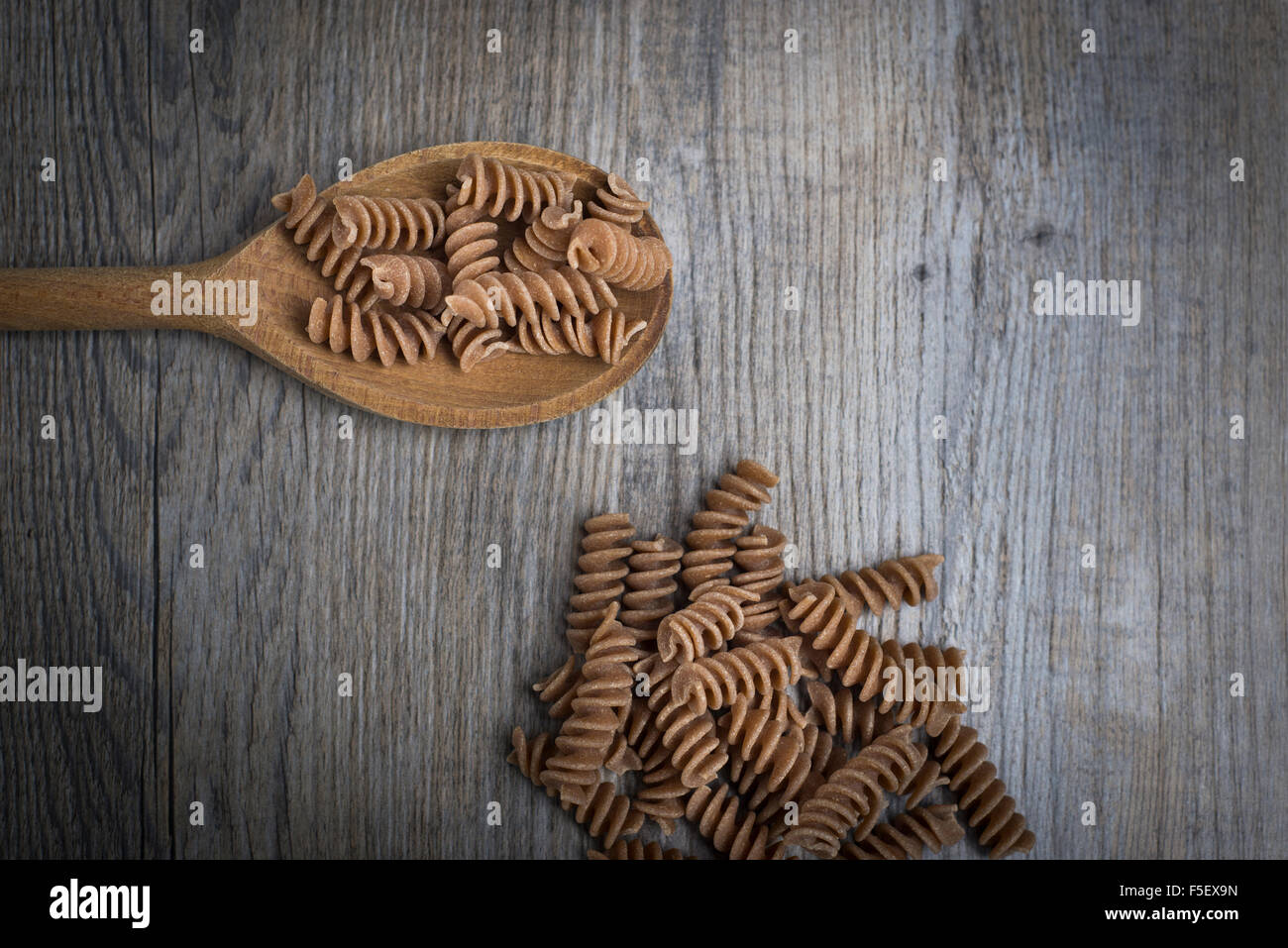 Wholegrain, spelt fusilli pasta with a wooden spoon Stock Photo - Alamy