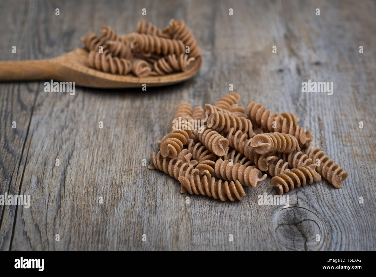 Wholegrain, spelt fusilli pasta with a wooden spoon Stock Photo - Alamy
