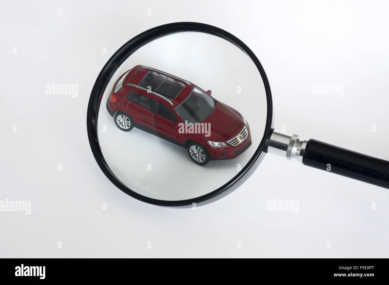 Illustration - A Volkswagen car model 'VW Tiguan' behind a magnifying ...