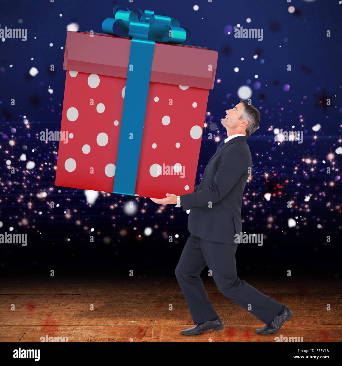 Composite image of stylish man with giant gift Stock Photo - Alamy