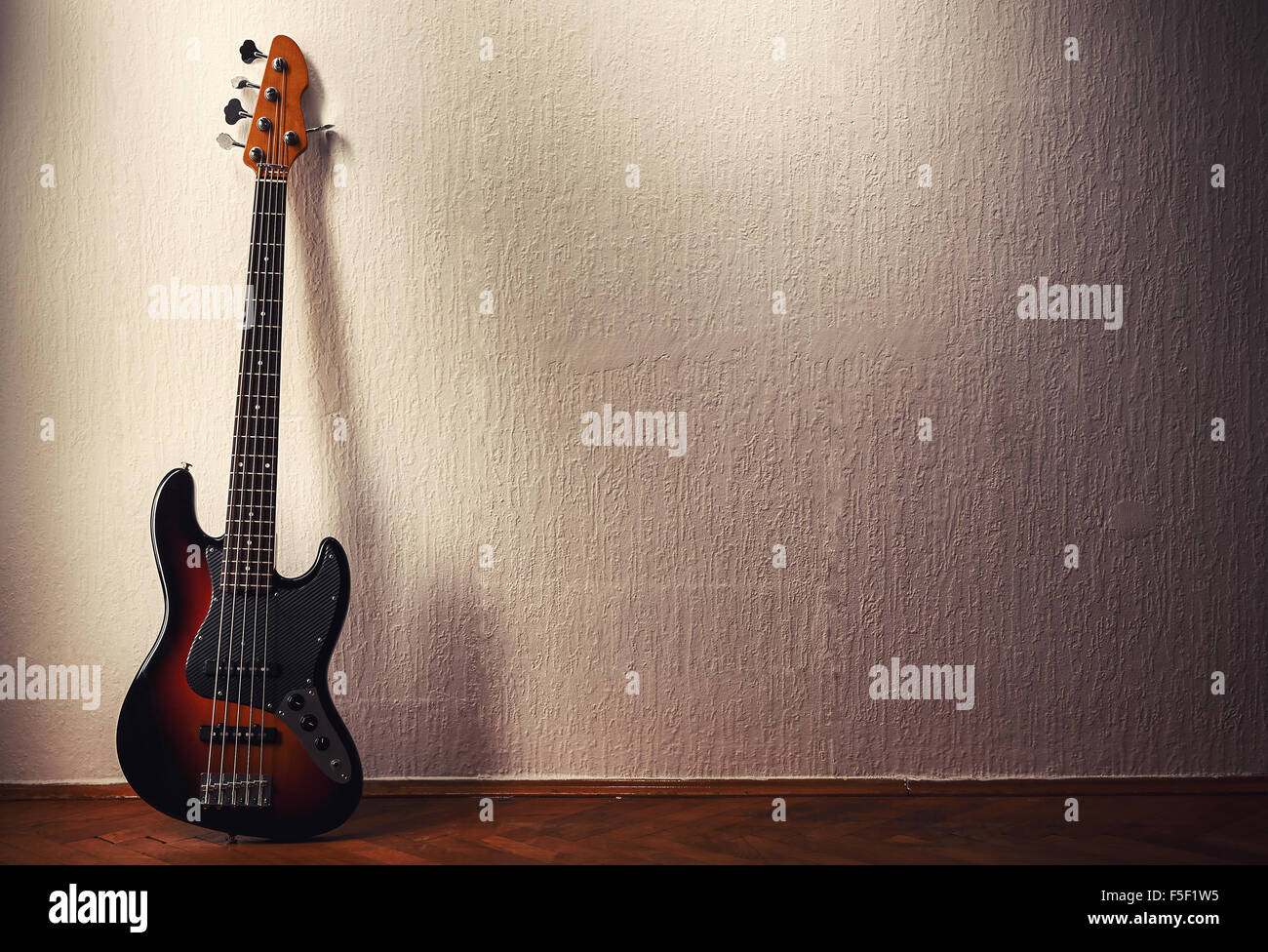 Five string jazz bass leaning to the wall Stock Photo - Alamy