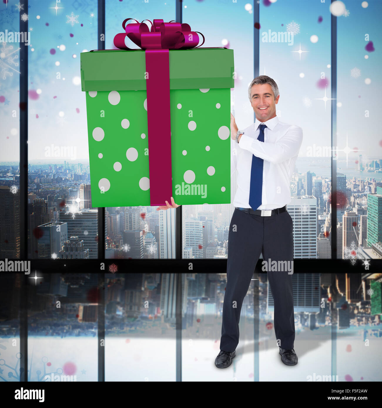 Composite image of stylish man with giant gift Stock Photo - Alamy