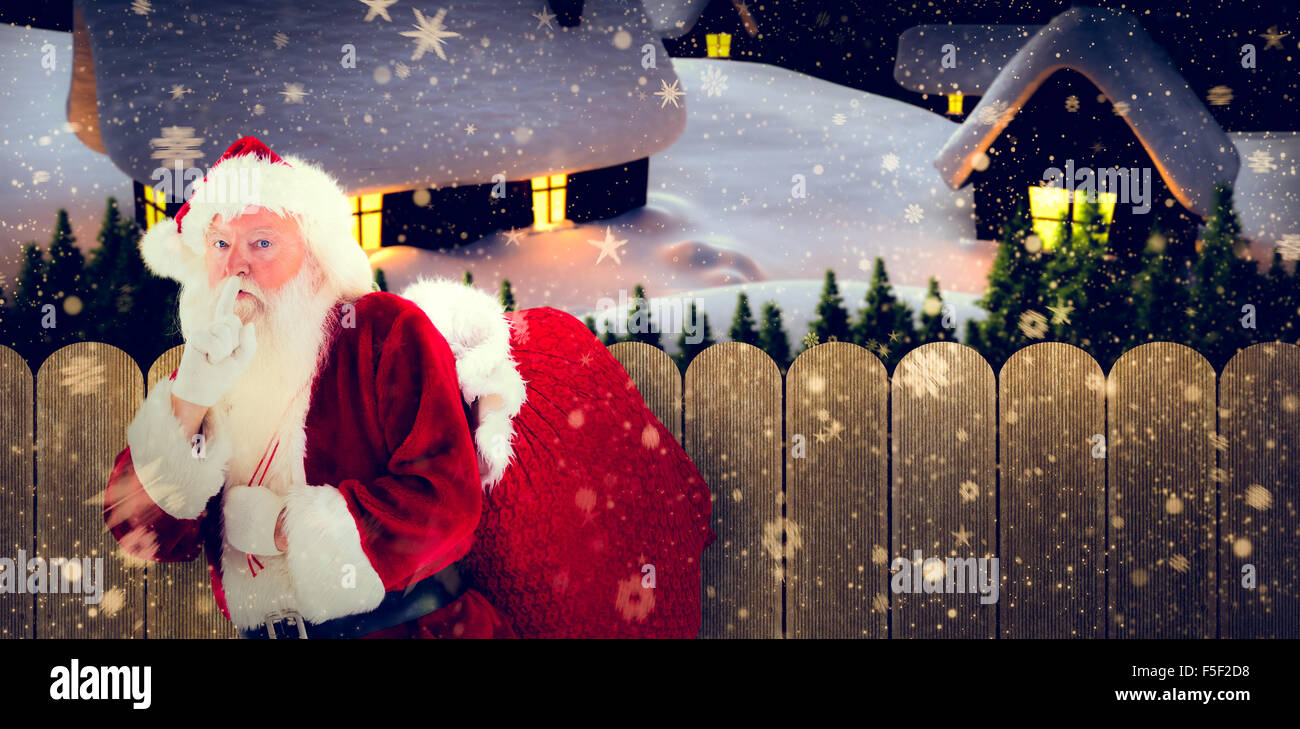 Composite image of santa asking for quiet with bag Stock Photo - Alamy