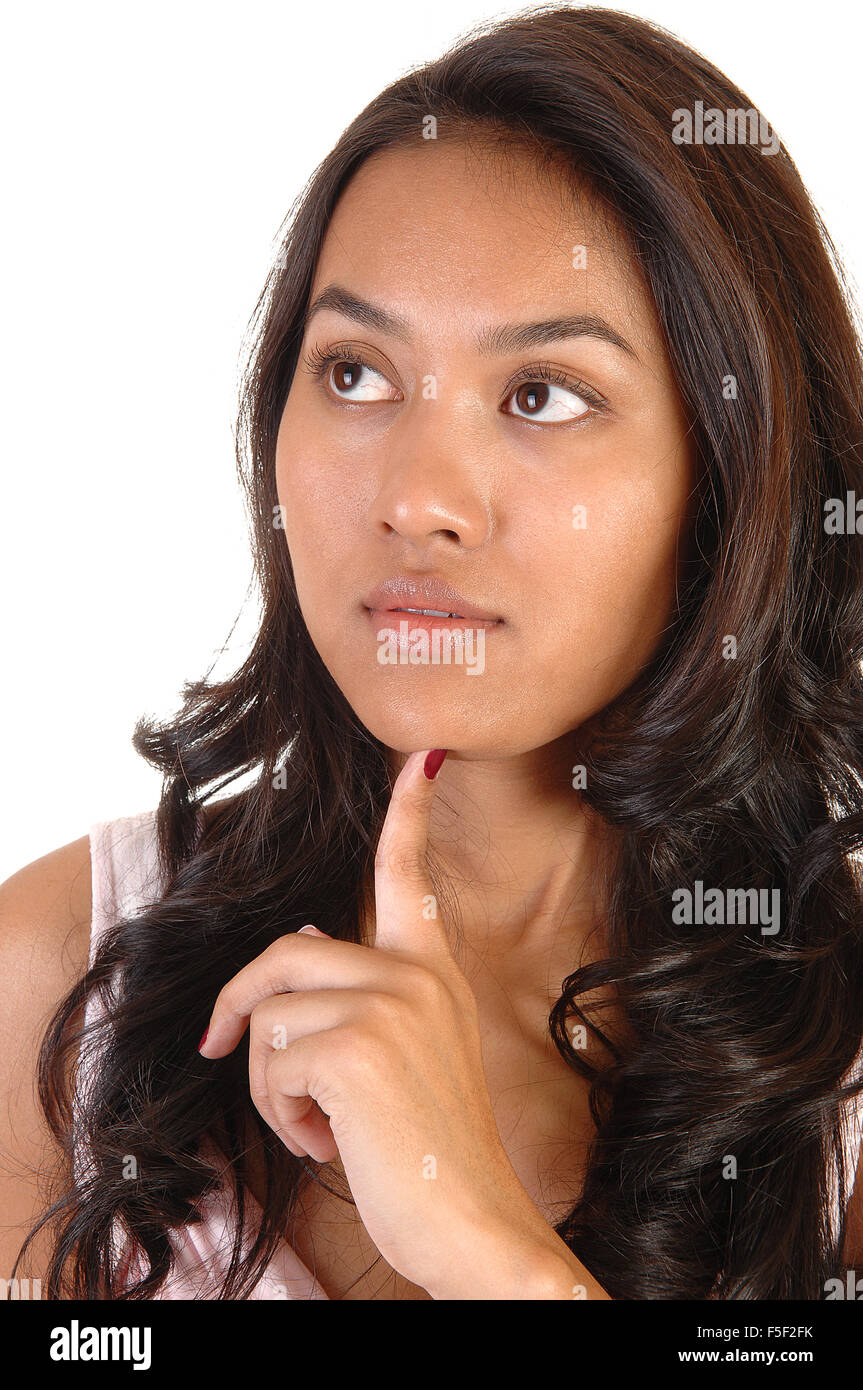 A lovely Asian girl, having one finger under her chin, looking up and ...