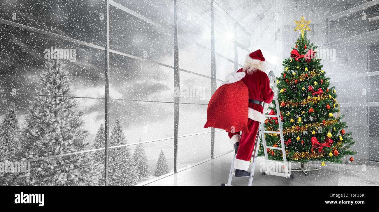 Composite image of santa steps up a ladder Stock Photo - Alamy