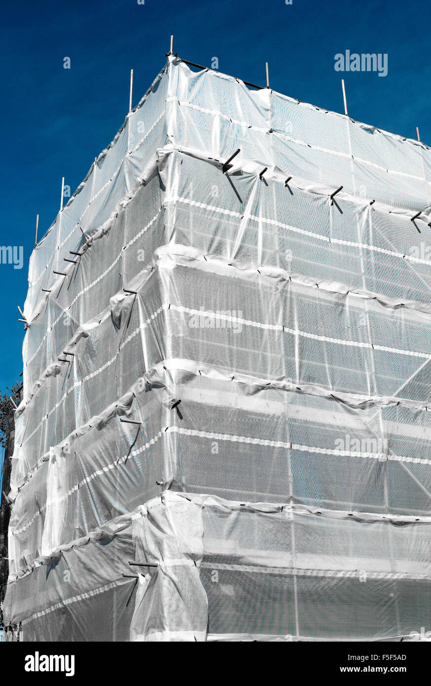 wrapped building scaffolding covered with white mesh Stock Photo - Alamy