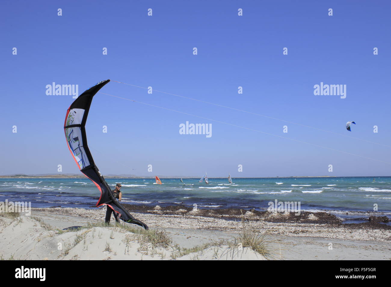 Parasurfer folding his kite struts on Keros bay beach, Lemnos or limnos ...