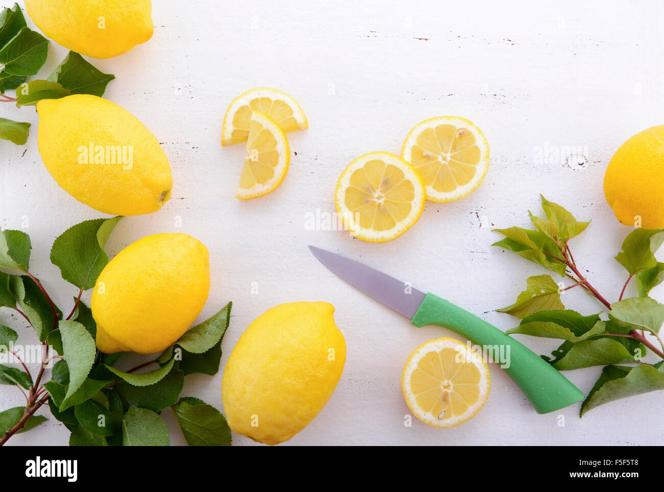 Slicing and preparing lemons on rustic white wood table Stock Photo - Alamy
