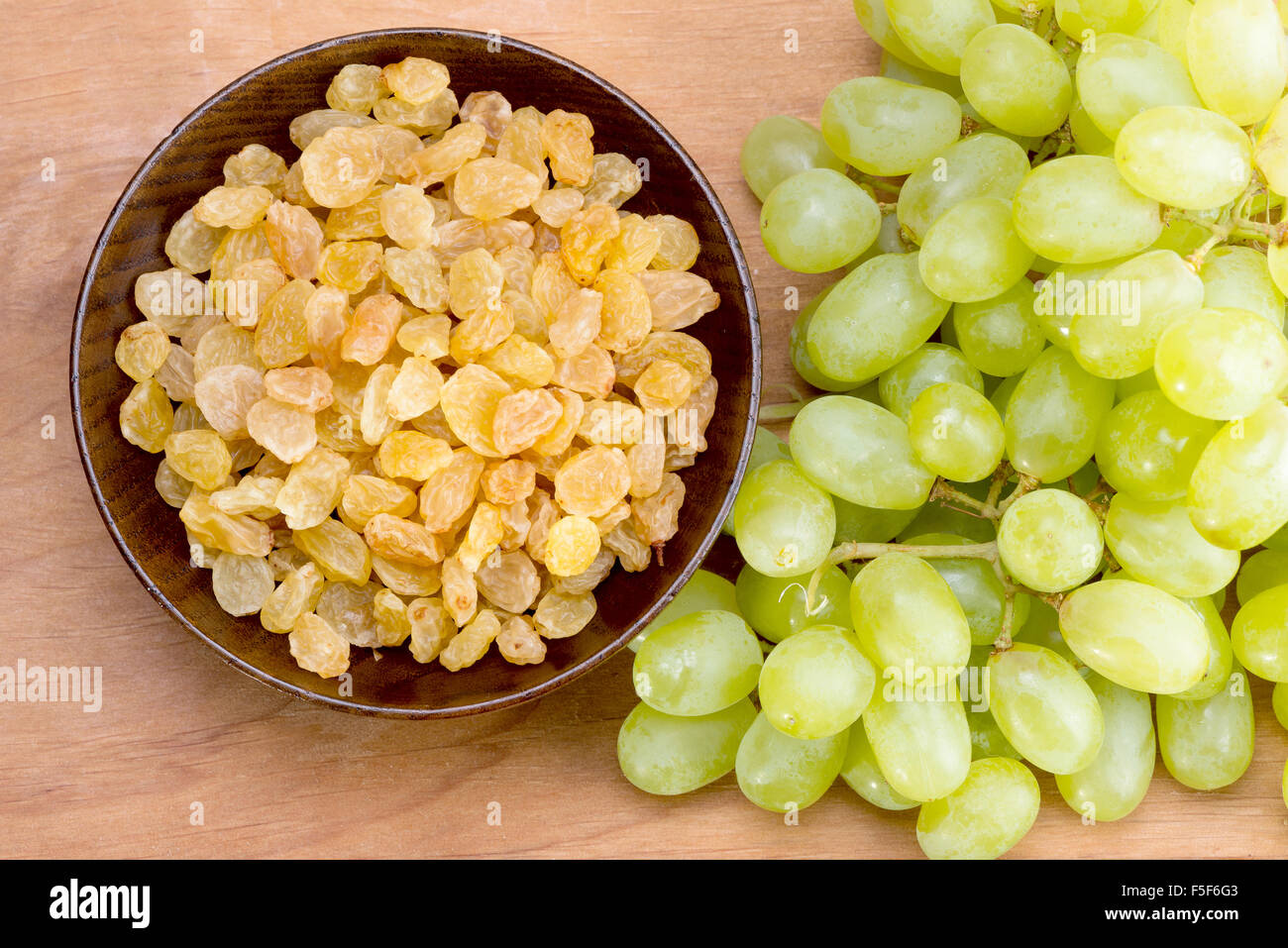 white seedless grapes and raisins sultanas in a wooden bowl Stock Photo ...