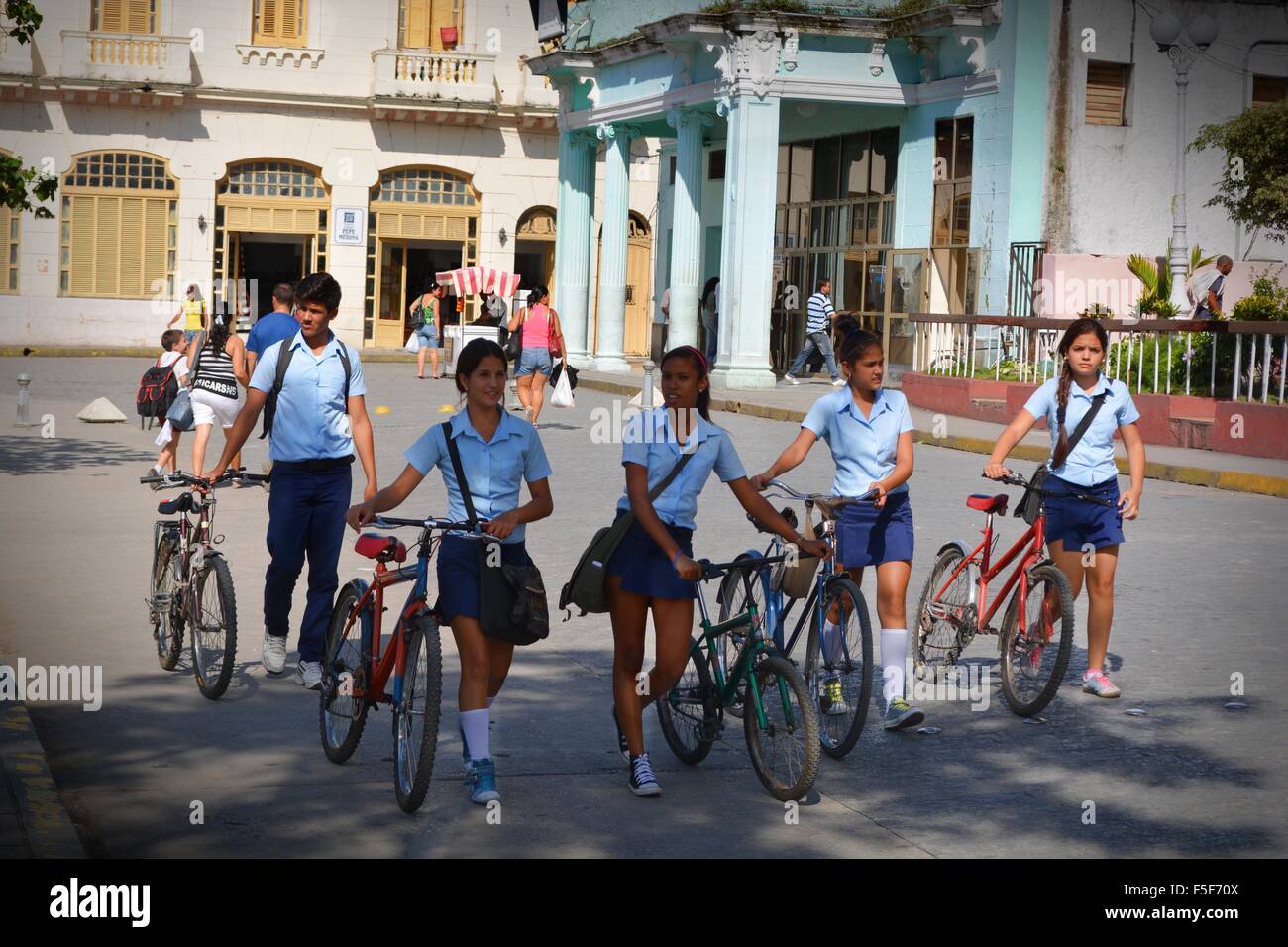 Cuban school kids in blue uniform with their bicycles walking in the ...