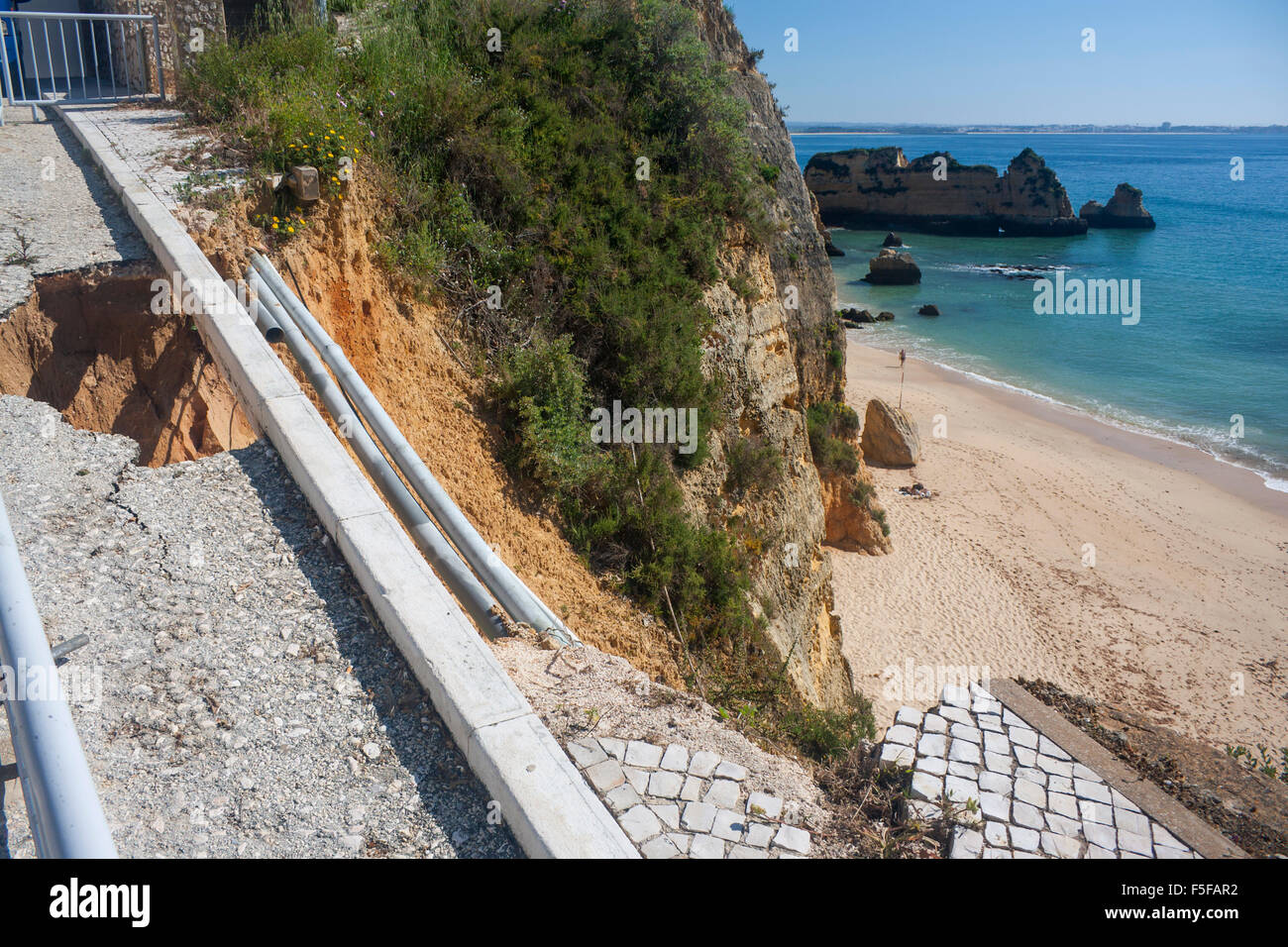 Coastal erosion collapsed footpath and paving on clifftop above Praia ...
