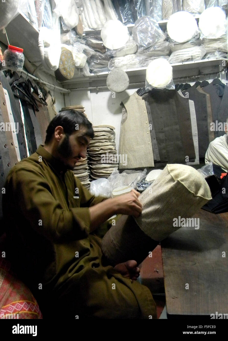 Peshawar. 3rd Nov, 2015. A craftsman knits a traditional cap at a ...