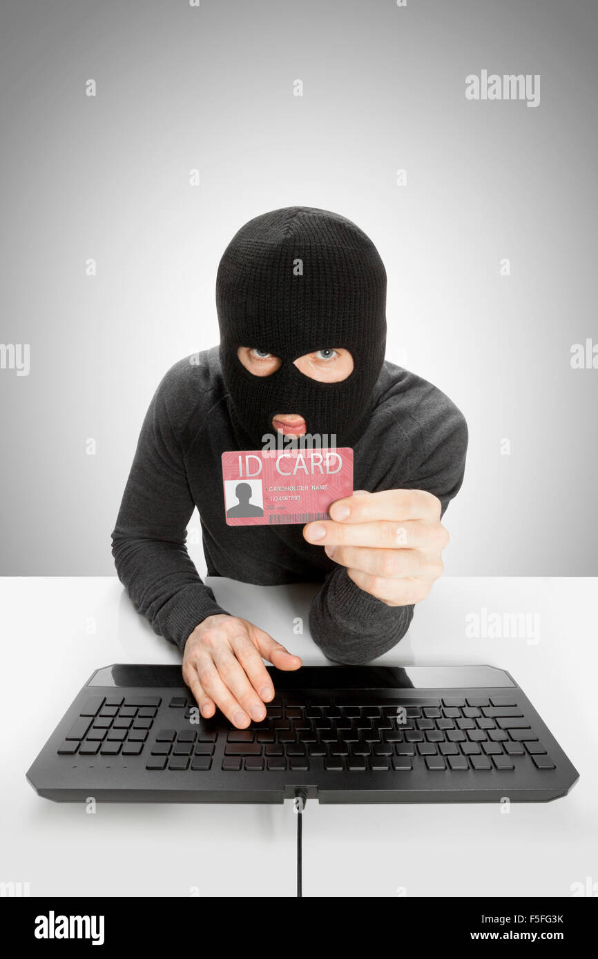 Hacker with ID card in hand Stock Photo - Alamy