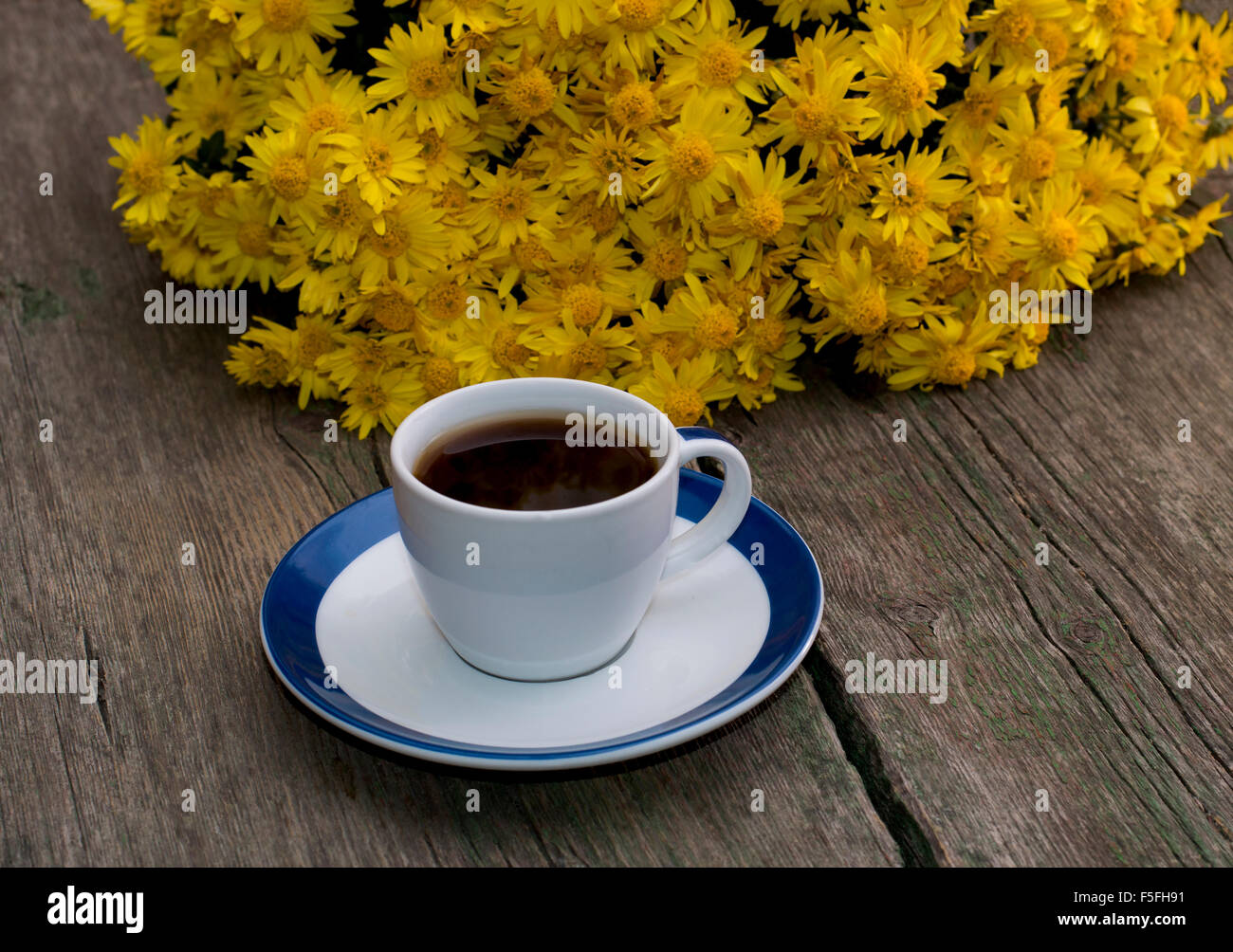 bouquet of beautiful yellow flowers and cup of black coffee, still life ...